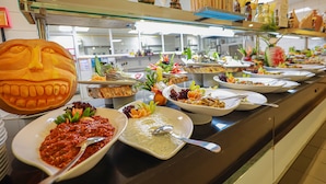 Buffet com diversos pratos e uma grande peça central decorativa.