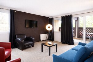 Suíte, 1 cama Queen e sofá-cama, sacada, vista para o jardim | Área de estar | TV de tela plana