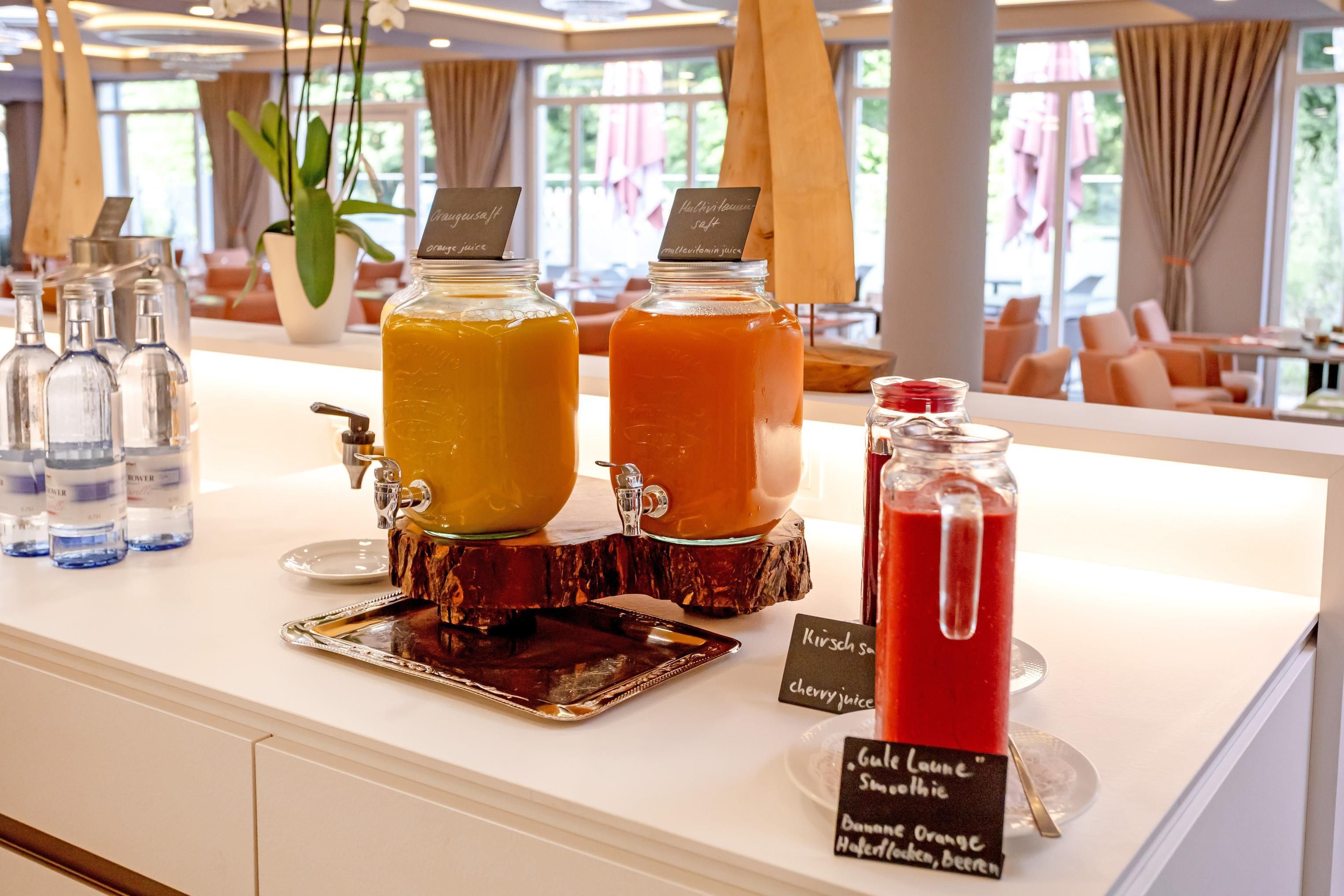 Um bar de sucos com diversos sabores de frutas e garrafas de água.