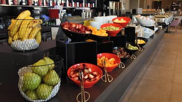 Um buffet com diversas frutas e bebidas.