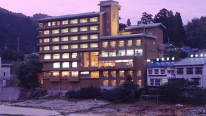 Um hotel com vários andares e design arquitetônico moderno, com uma torre central imponente e várias janelas.