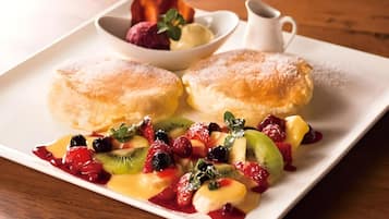 Um prato com panquecas e salada de frutas.