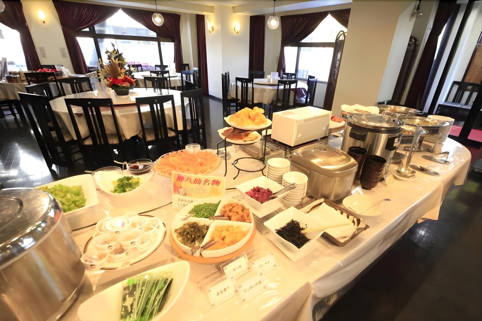 Disposição de buffet com diversos alimentos e utensílios de servir.