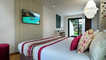 Quarto de hotel moderno com uma cama grande, TV de tela plana, escrivaninha e vista para o exterior.