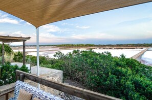 Uma área de estar coberta ao ar livre com vista para a paisagem costeira.