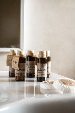 Conjunto de garrafas Salinera naturais com rótulos sobre uma superfície refletora.