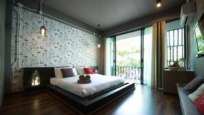Quarto moderno com uma cama grande, parede com padrão de pedra e varanda com vista.