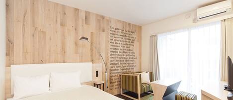 Quarto de hotel com cama grande, escrivaninha, cadeira, televisão e janela com cortinas.