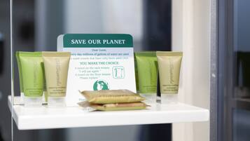 Exposição de produtos Earthbath com um aviso incentivando hóspedes a proteger o planeta reutilizando toalhas.