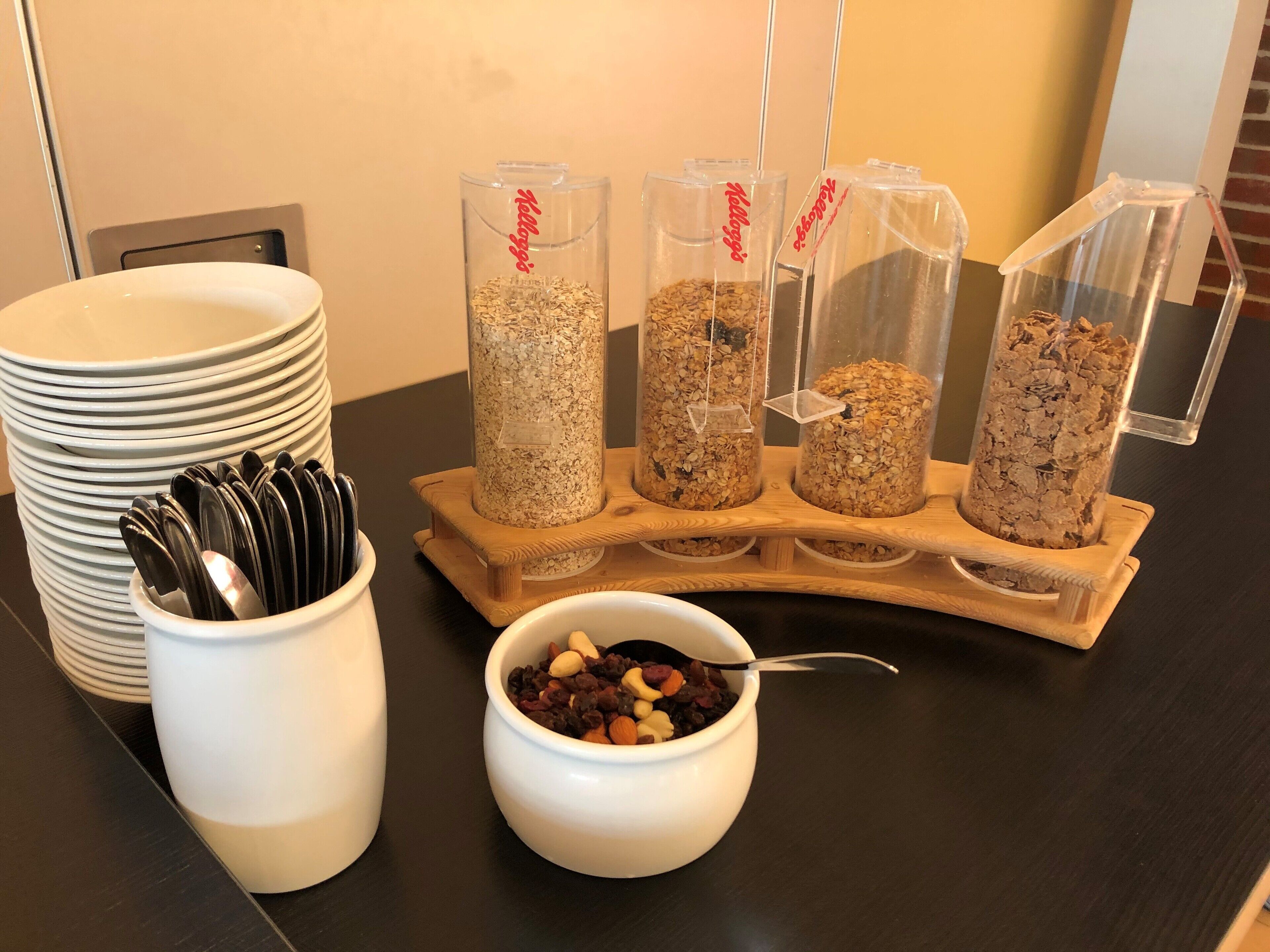 Disposição para o café da manhã com várias tigelas de cereal e uma tigela de mix de castanhas.