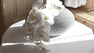 Uma orquídea branca sobre uma superfície de pedra texturizada.