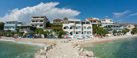 Na praia, espreguiçadeiras, guarda-sóis de praia, toalhas de praia