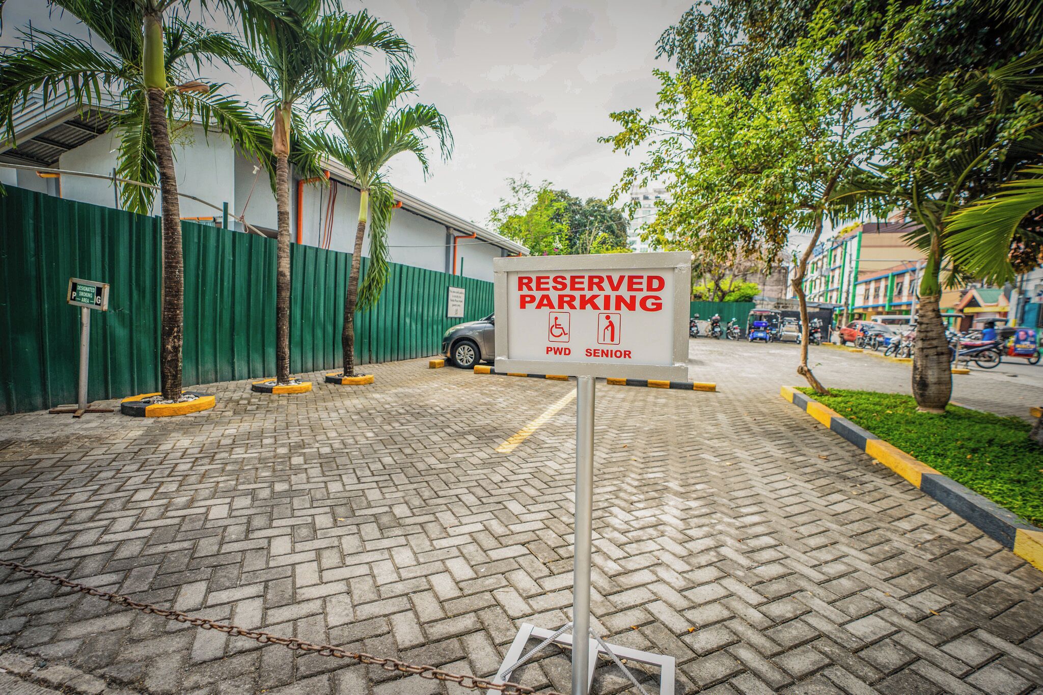 Sinal de vaga reservada com símbolos de acessibilidade para deficientes e idosos, indicando espaços de estacionamento designados.