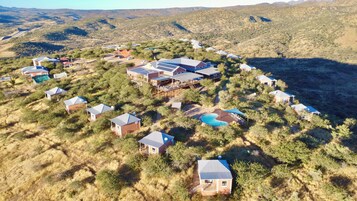 Área residencial com várias casas, uma piscina e um edifício grande com terraço.