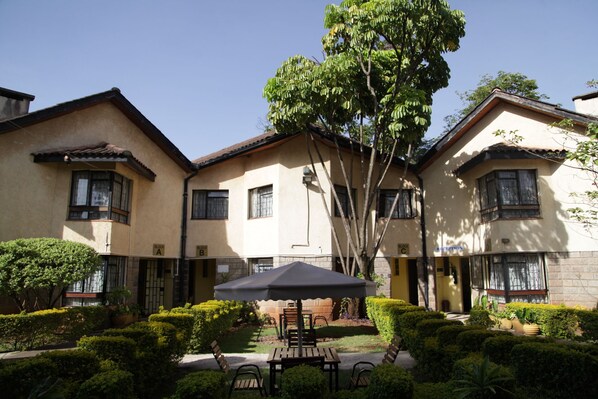 Um edifício com várias janelas e um pátio com mesa e cadeiras.