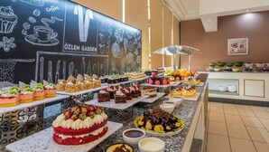 Buffet com diversos doces e um cardápio em lousa.