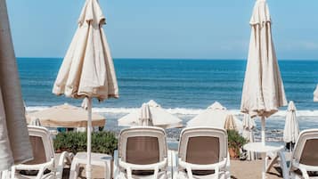 Uma praia privada, espreguiçadeiras, guarda-sóis de praia