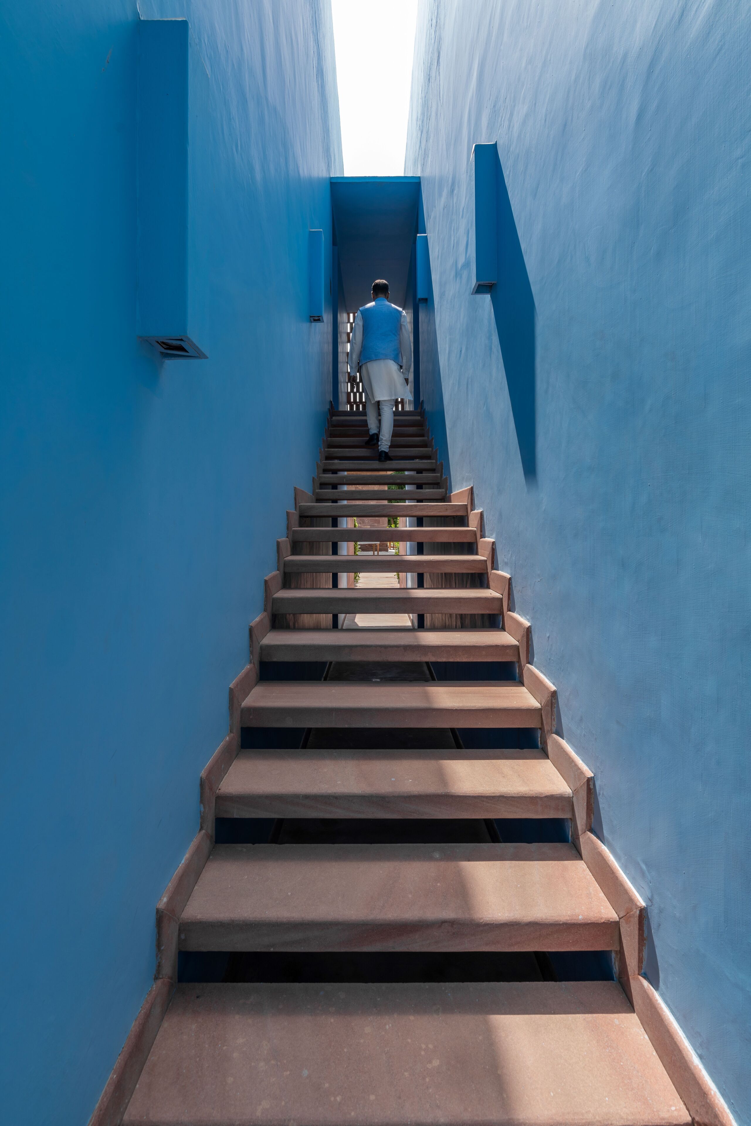 Uma escadaria com uma pessoa descendo.