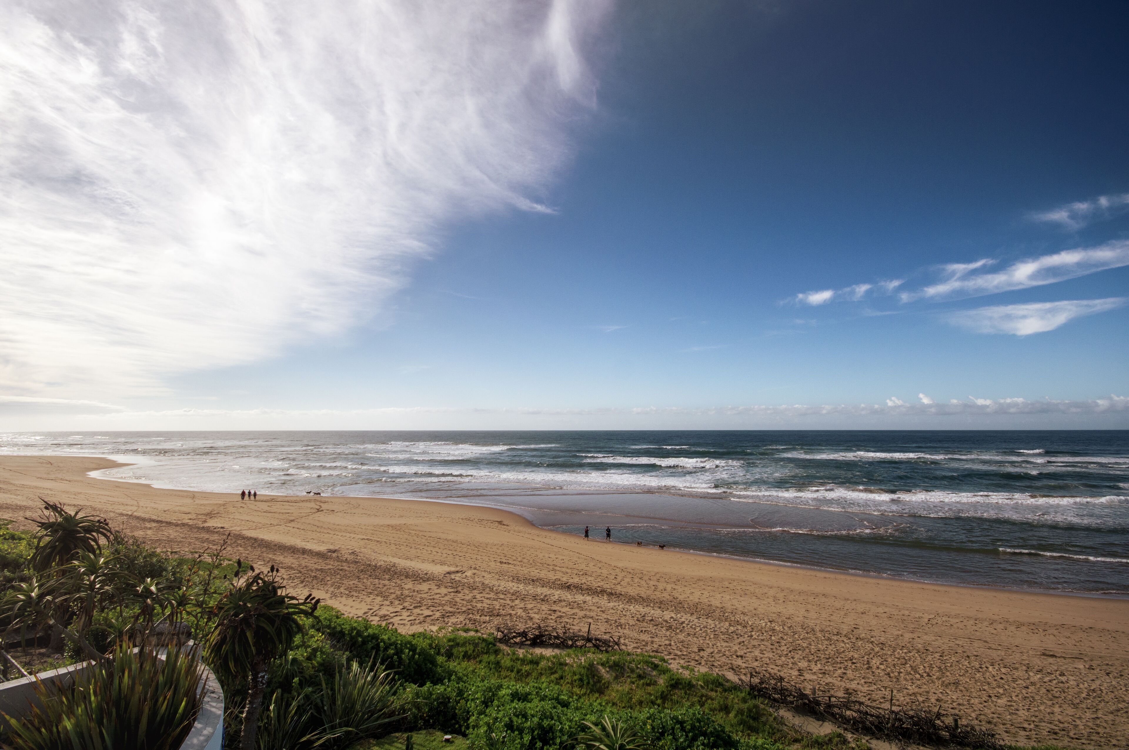Uma praia com céu claro e ondas do oceano.