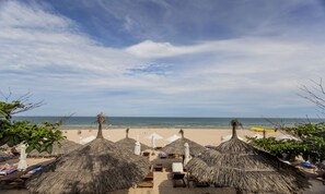 Uma praia privada, praia de areia branca, guarda-sóis de praia 
