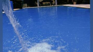 Piscina com um recurso de fonte de água.