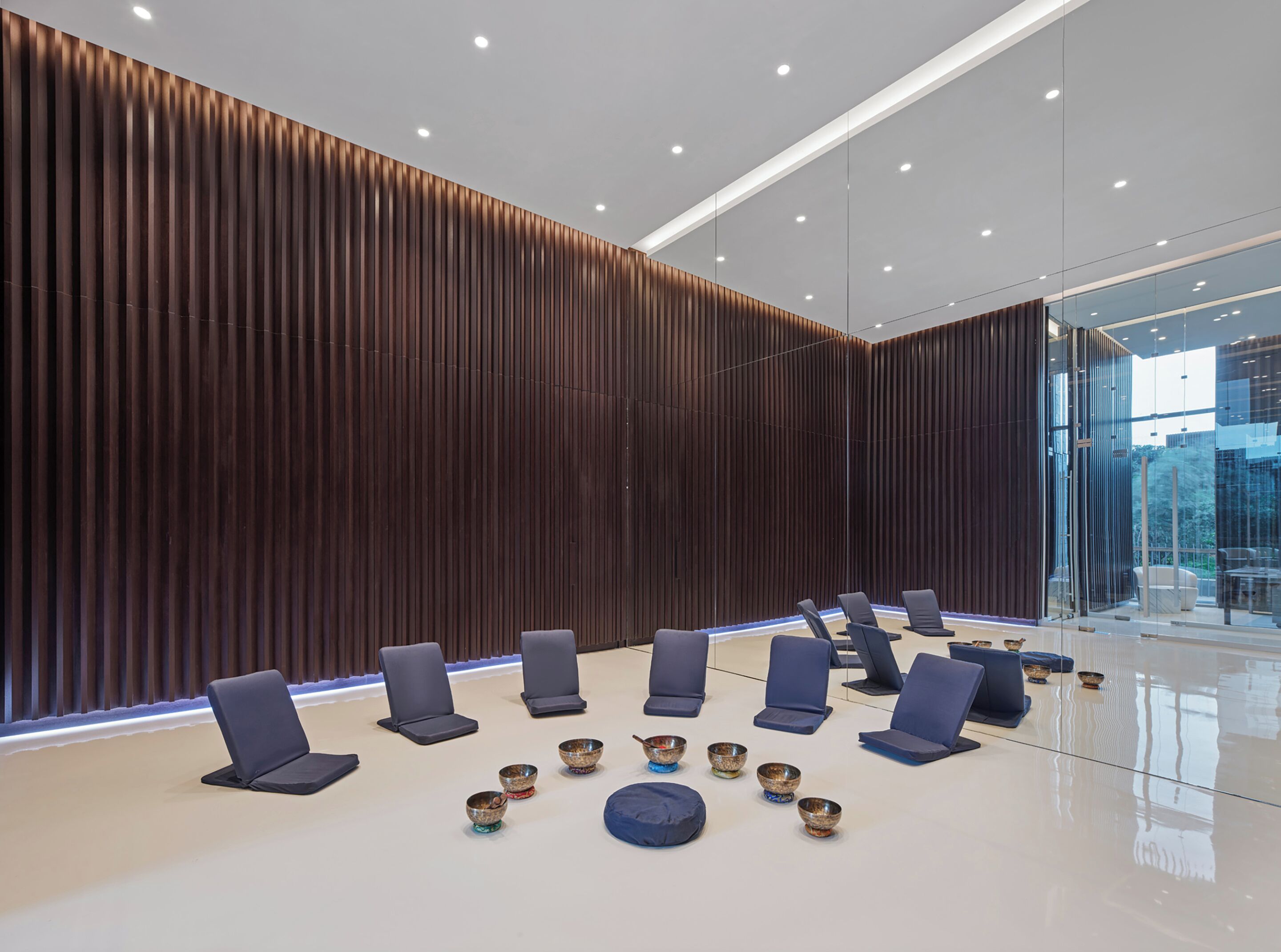 Uma sala de conferências moderna com um painel de parede de madeira elegante, uma divisória de vidro e piso polido.