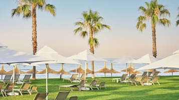 Uma praia privada, espreguiçadeiras, guarda-sóis de praia
