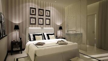 Um quarto moderno com uma cama grande, quadros nas paredes e uma janela com persianas.
