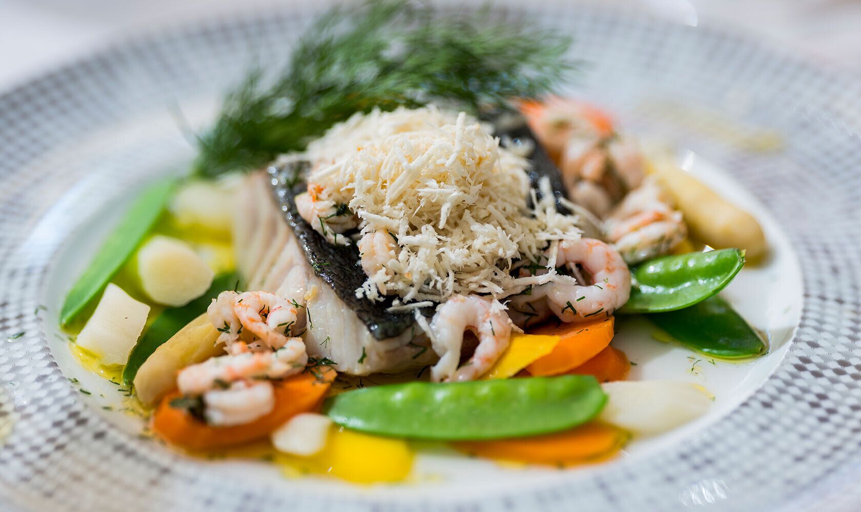 Prato de frutos do mar com camarão, peixe e legumes.