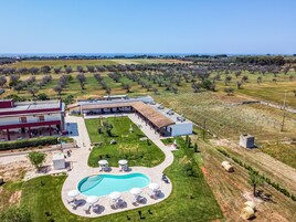 Um resort com piscina, área de estar externa e um edifício grande com vários quartos.