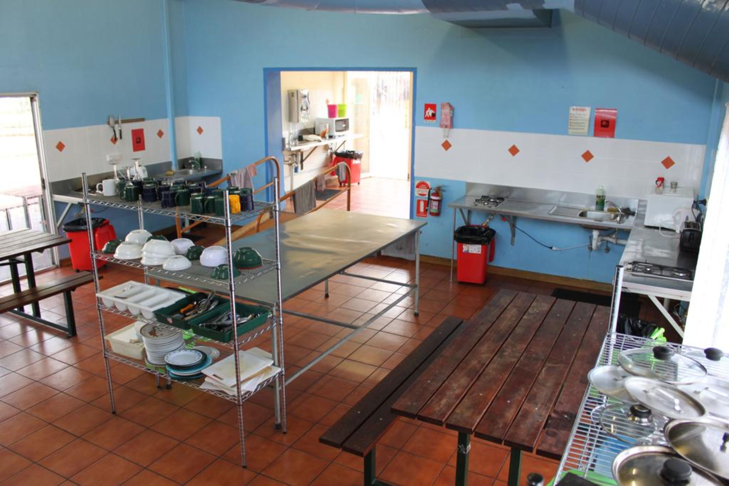 Uma cozinha com eletrodomésticos de aço inoxidável, um banco de madeira e piso de azulejos.