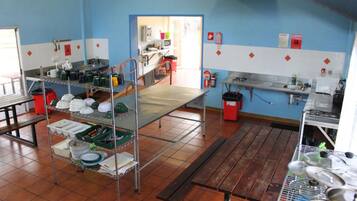 Uma cozinha com eletrodomésticos de aço inoxidável, um banco de madeira e piso de azulejos.