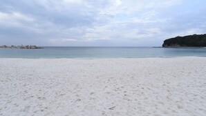 Uma praia com areia branca e águas calmas.