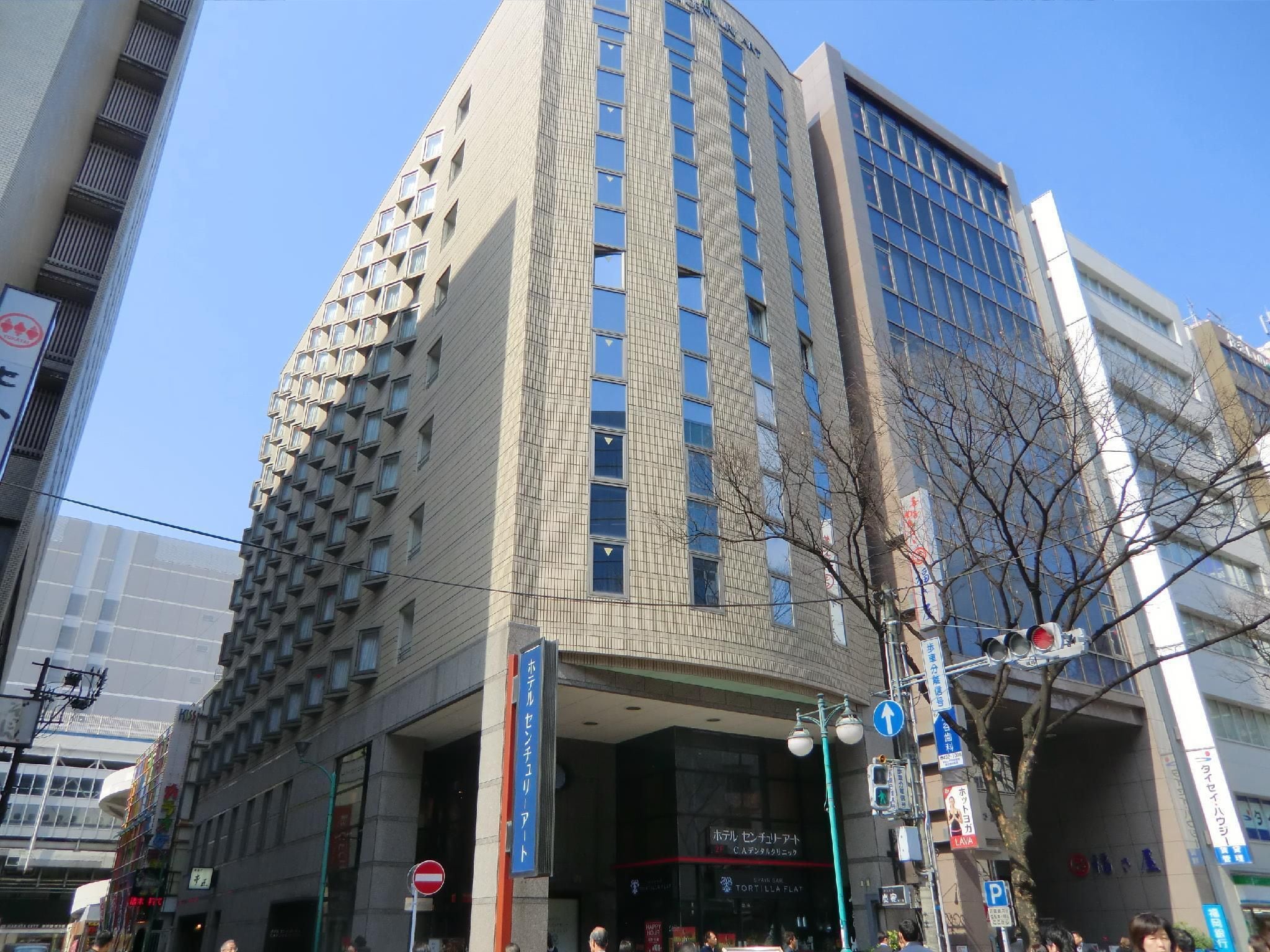 Um edifício moderno com fachada única, apresentando uma combinação de padrões geométricos e grandes janelas.