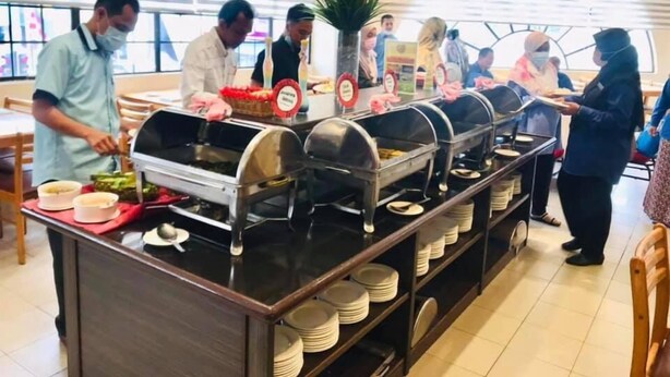 Disposição de buffet com várias estações de comida e uma variedade de pratos.