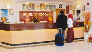Bancada de recepção de hotel com uma placa indicando "HOTEL YT MIDTOWN".