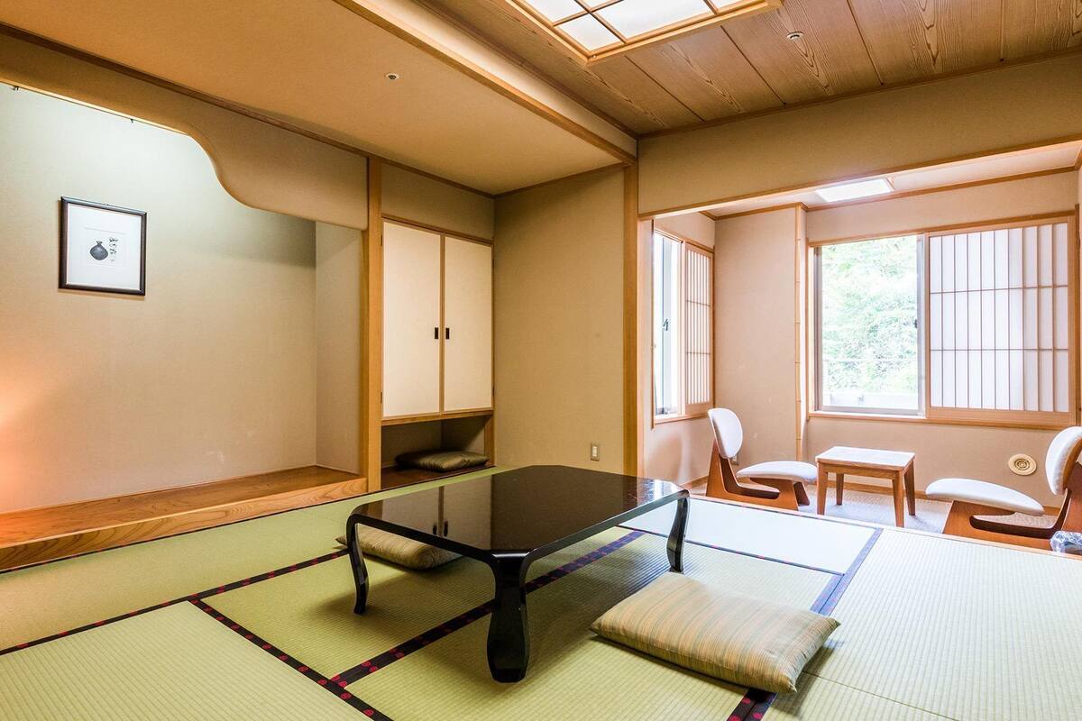 Um quarto japonês tradicional, com tatames, uma mesa baixa e portas corrediças.