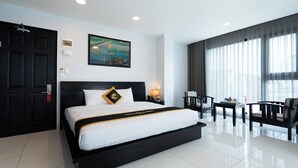 Quarto de hotel moderno com uma cama grande, uma mesa e uma cadeira.