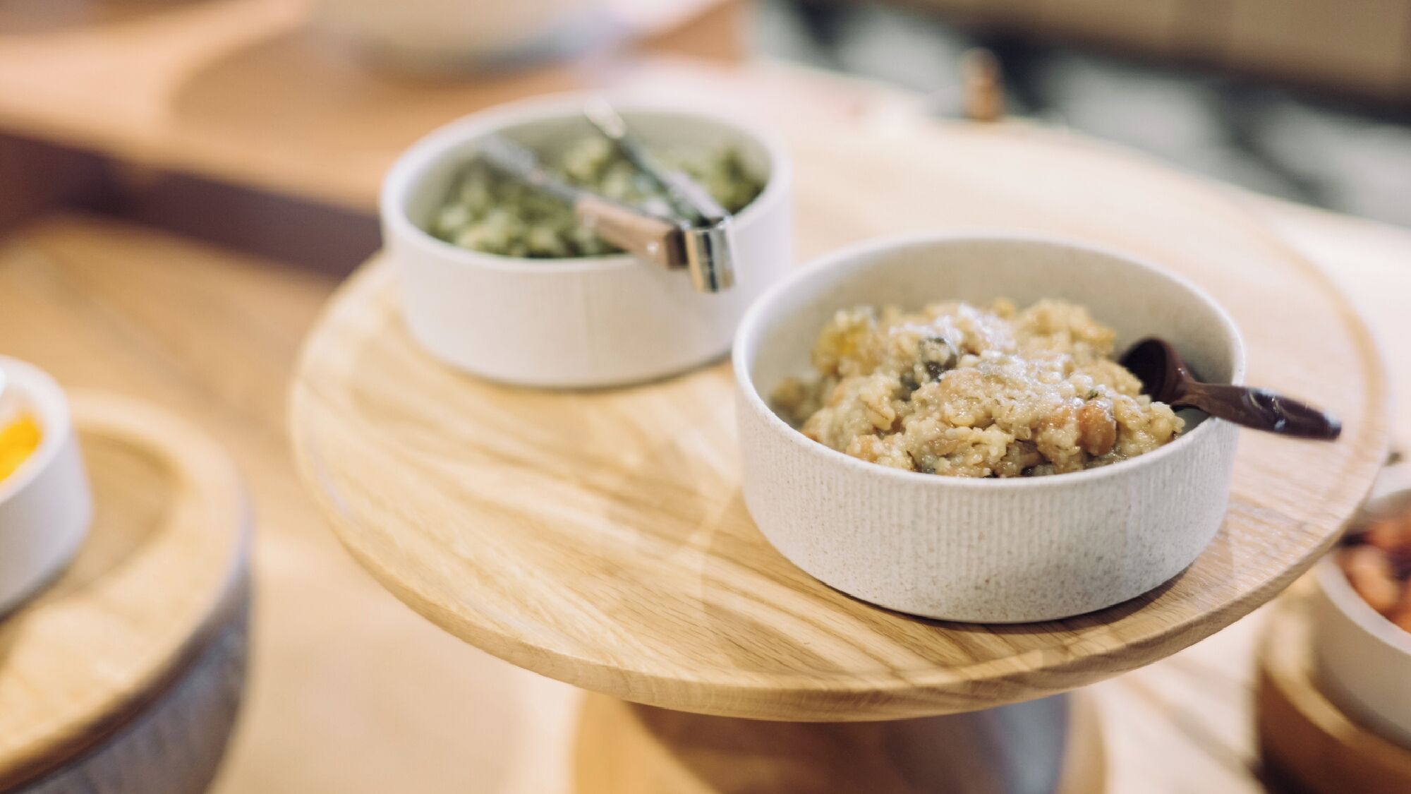 Duas tigelas de comida sobre uma tábua de madeira.