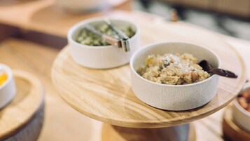 Duas tigelas de comida sobre uma tábua de madeira.
