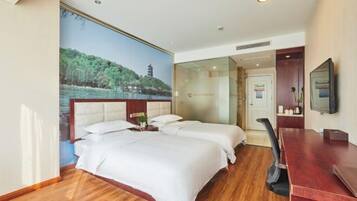 Quarto de hotel com duas camas, piso de madeira, grande janela com vista para um lago e um pagode, escrivaninha com cadeira e televisão na parede.