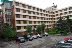 Um hotel com vários andares e estacionamento.