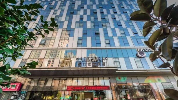 Um edifício moderno com fachada de vidro e uma placa com a inscrição 'EASTIN'.