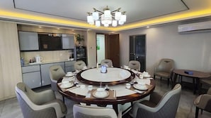 Uma sala de jantar moderna com uma mesa redonda posta para seis pessoas, rodeada por seis cadeiras.