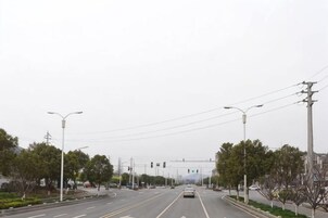 Uma estrada com várias faixas, semáforos e postes de luz.