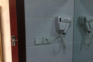 Secador de cabelo fixado na parede, com tomada e fio.