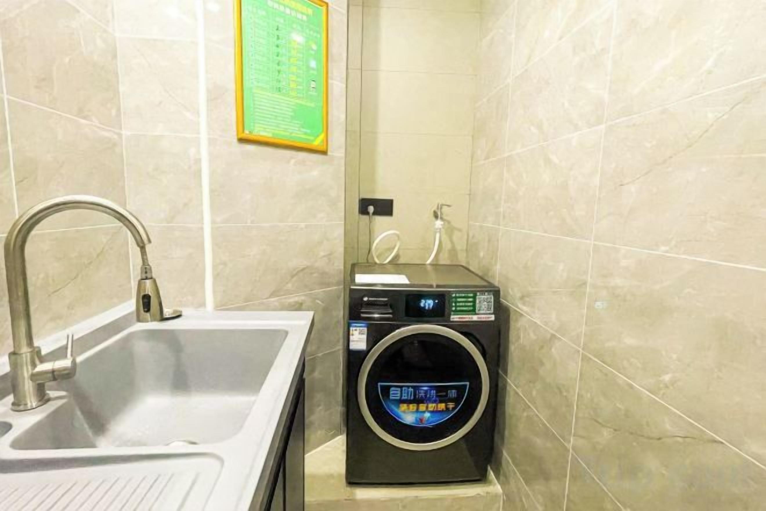 Casa de banho com lavatório, máquina de lavar e espelho fixado na parede.