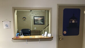 Um balcão de recepção com um espelho, um quadro emoldurado e uma placa.