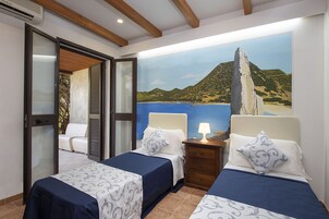 Quarto com duas camas, uma mesa de cabeceira com abajur e uma pintura grande de paisagem costeira.