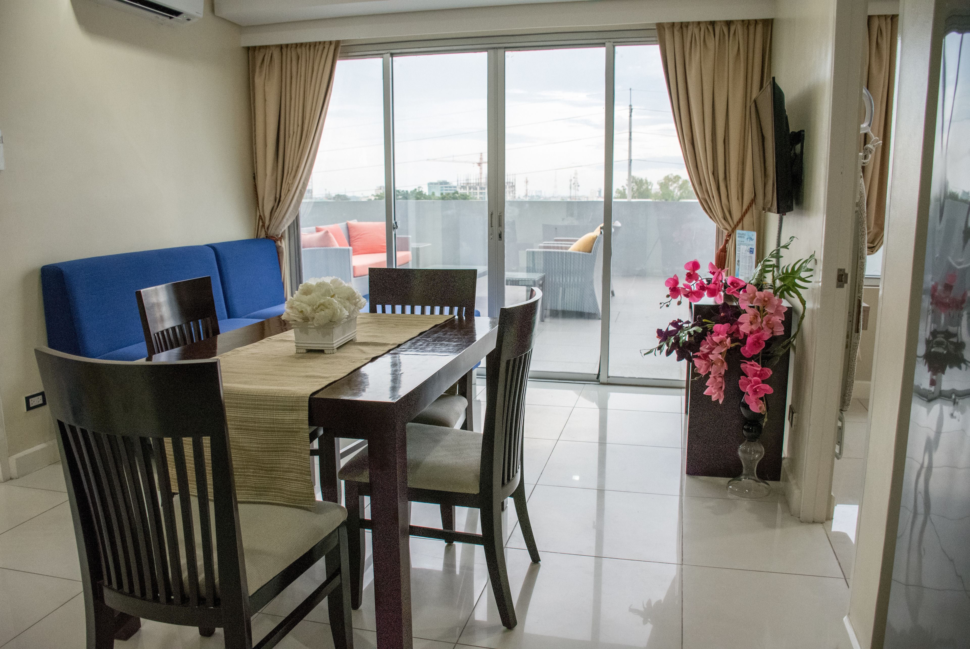 Uma sala de jantar com mesa, cadeiras e um sofá.